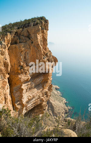 Steep cliffs in the Sierra Helada natural park with the small island of ...