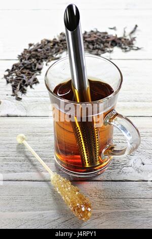 Black tea with candy sugar in a tea glass on a wooden table Stock Photo ...