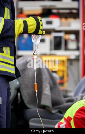 First aid by firefighter holding infusion Stock Photo - Alamy