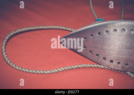 smoothing iron on red background Stock Photo - Alamy
