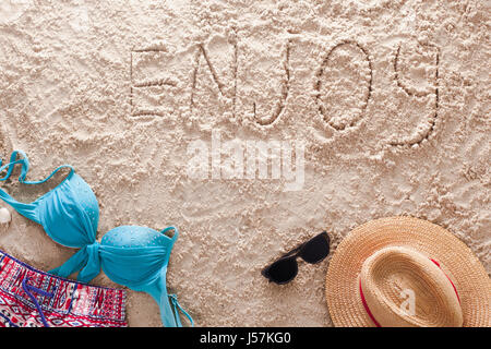 Enjoy written in a sandy tropical beach Stock Photo - Alamy