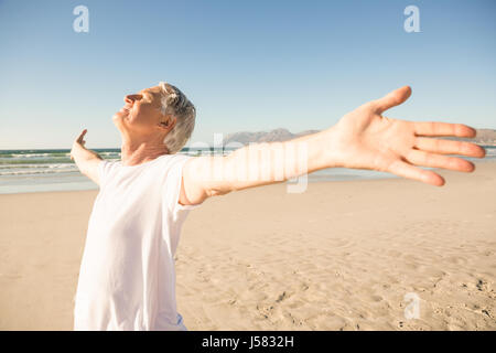 Senior man with arms outstretched standing on boat deck moored at ...