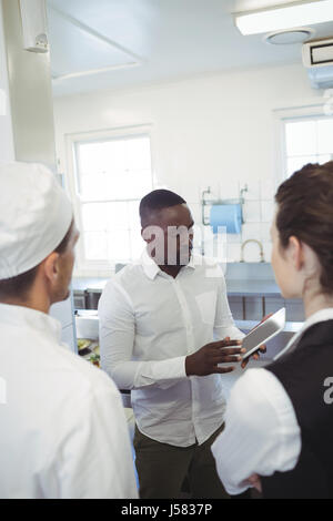 Restaurant manager briefing to his kitchen staff Stock Photo - Alamy