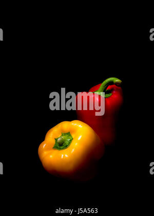 Red bell peppers on yellow background Stock Photo - Alamy