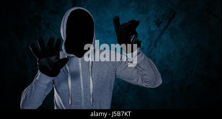 Robber with hood and gloves against dark background Stock Photo - Alamy