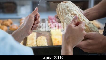 Digital composite of Hands photographing bread on transparent device ...