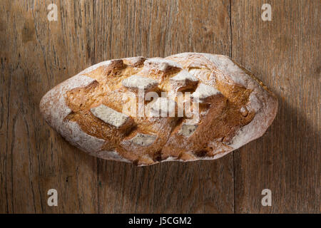 Above view of a rustic loaf of bread on an old wooden table Stock Photo ...