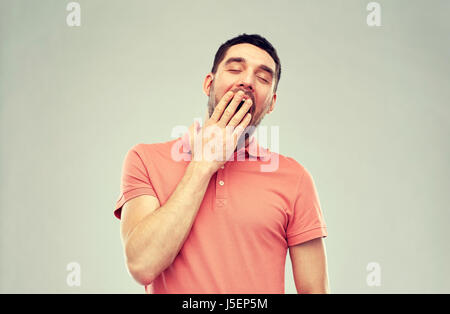 yawning man over gray background Stock Photo - Alamy