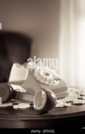 Vintage telephone on doily and wooden table in the living room Stock ...