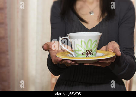 Woman offering a cup of tea (blurring Stock Photo - Alamy