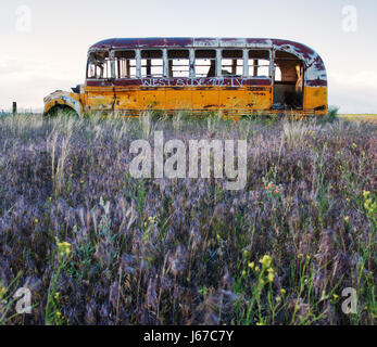 stripped rusty, old abandoned bus wreck in arid mountainous landscape ...