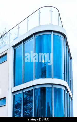 Abstract reflections of buildings in the curved green glass façade of ...