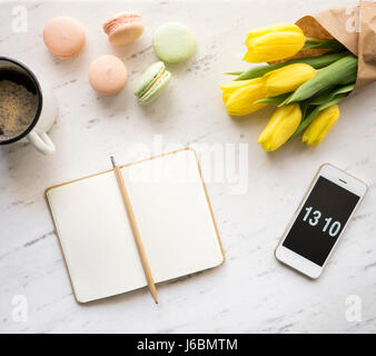 bouquet of yellow tulips and smartphone on blue wooden background Stock ...