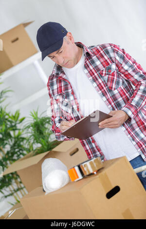 Checking off a checklist on a clipboard on a table Stock Photo - Alamy