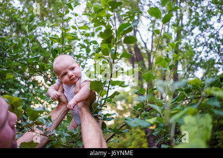 Man holding a baby boy aloft, both smiling Stock Photo - Alamy