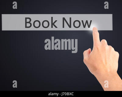 Book Now - Hand pressing a button on blurred background concept ...