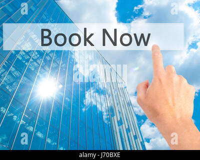 Book Now - Hand pressing a button on blurred background concept ...