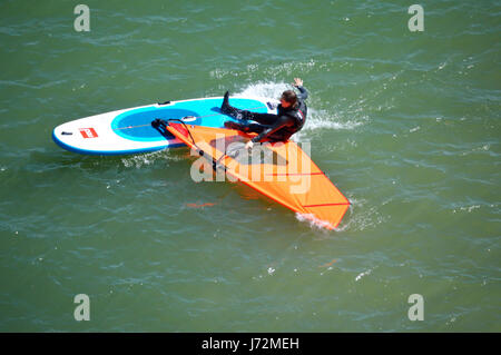 A girl learning to surf falling off her board Stock Photo - Alamy