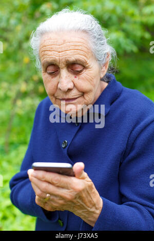 old female hands holding smartphone with green screen over wood vintage ...