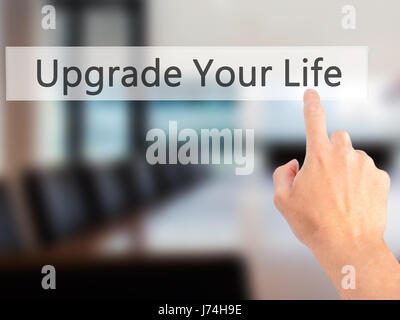 Upgrade Your Life - Hand pressing a button on blurred background ...
