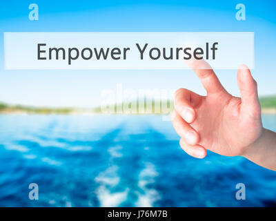 Empower Yourself - Hand pressing a button on blurred background concept ...