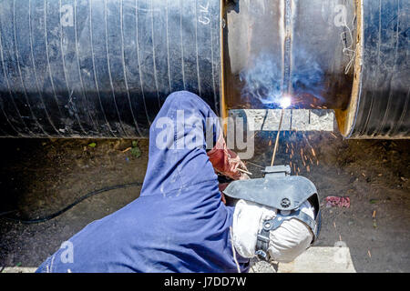 Welder is in trench working hard, arc welding pipeline Stock Photo - Alamy