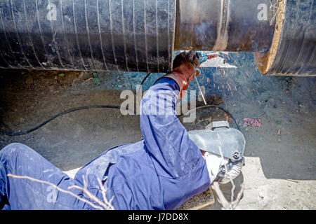 Welder is in trench working hard, arc welding pipeline Stock Photo - Alamy
