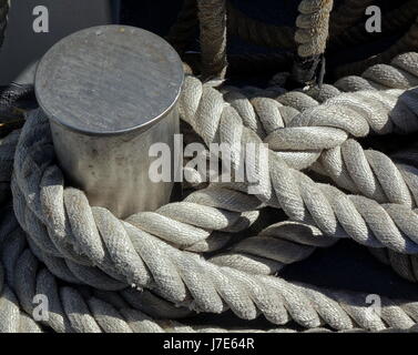 A thick rope is wrapped around a strong post on deck of a ship Stock ...