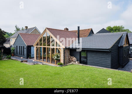 Exterior facade of converted barn with wood cladding and tiled roof ...