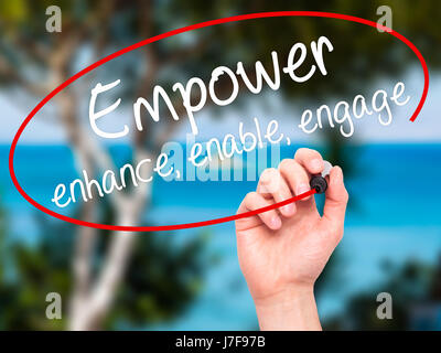 Man Hand writing Empower enhance, enable, engage with black marker on ...