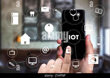 IOT business man hand working and internet of things (IoT) word diagram ...