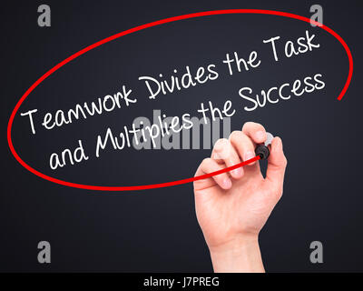 Man Hand writing Teamwork Divides the Task and Multiplies the Success ...