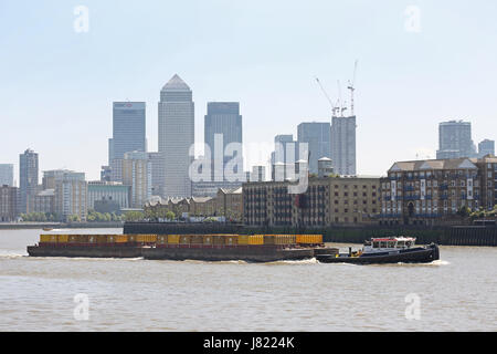 A Thames tug boat tows container barges on River Thames in central ...