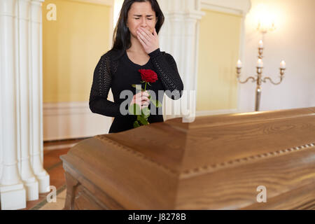 crying woman with red rose and coffin at funeral Stock Photo - Alamy