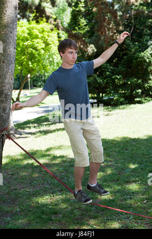 Portrait of man on slackline. Slacklining is a practice in balance ...