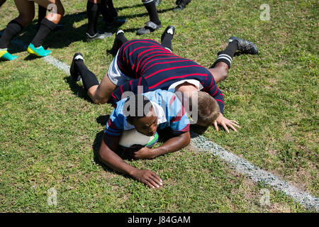 High angle view of man chasing ball while playing rugby Stock Photo - Alamy