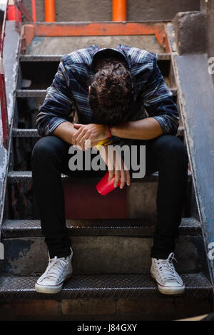 Drunk man sitting on stairs. Alcoholism concept Stock Photo - Alamy