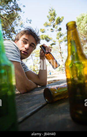 Drunken Young Man with Bottle of the Beer and Cellphone on the Sofa at ...
