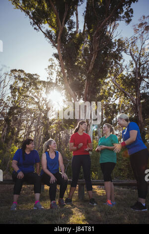 Group of fit women interacting with each other in the boot camp on a ...