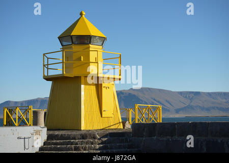 Yellow lighthouse in the Reykjavik, Iceland harbor with colorful and ...