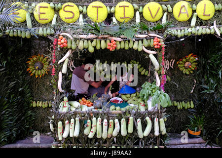 A Filipino man and his son arrange products in a structure elaborately ...