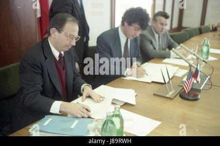 Military personnel sit and sign official documents, completing ...