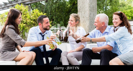 Office colleagues drinking beer after work Stock Photo - Alamy