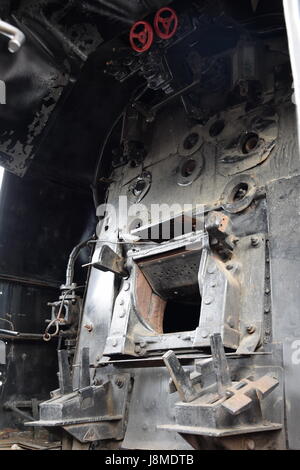 Interior of old vintage steam locomotive cabin. A coal with shovel in a ...