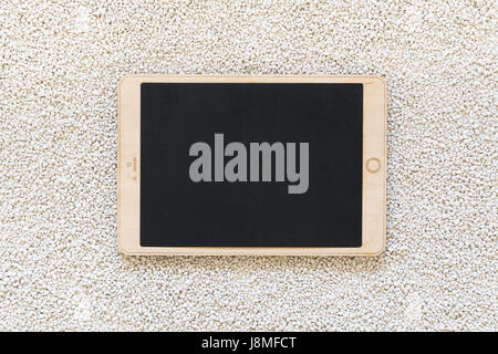 Tablet shaped chalk board on white pebbles background, flat lay Stock ...