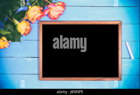 Red roses and empty chalk board on black background. Valentines Stock ...