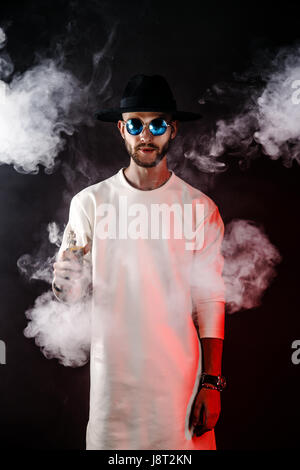 Stylish man in hat vaping Stock Photo - Alamy