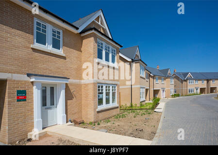 An empty street in a mostly complete new housing development, with ...