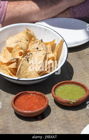 Plates with tasty nachos on green background Stock Photo - Alamy