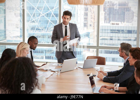 Businessman Stands To Address Meeting Around Board Table Stock Photo ...